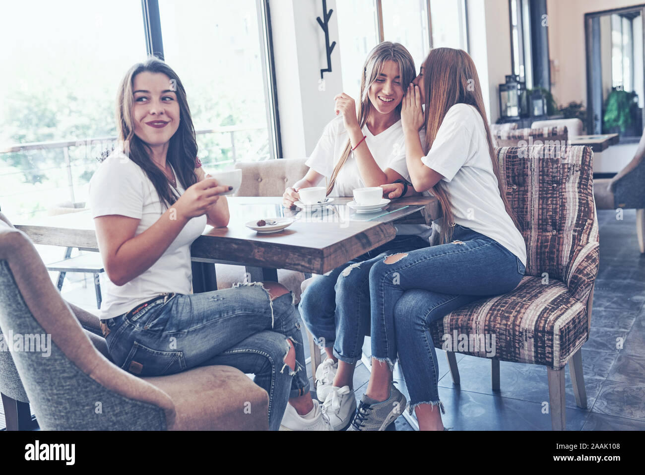 The three best girlfriends gathered to drink coffee and gossip. Girls ...