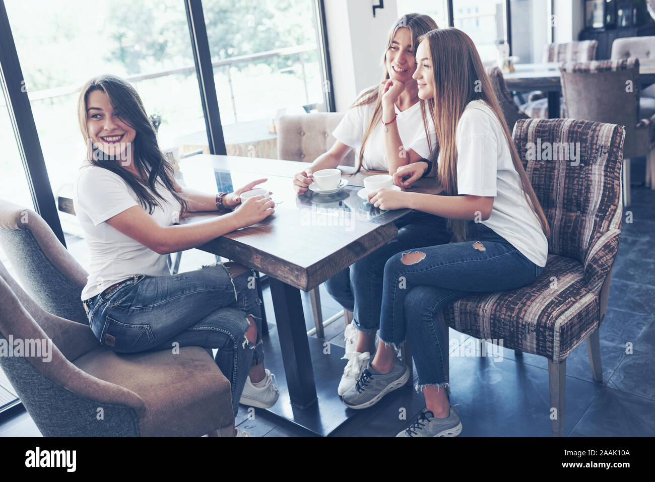 The three best girlfriends gathered to drink coffee and gossip. Girls ...