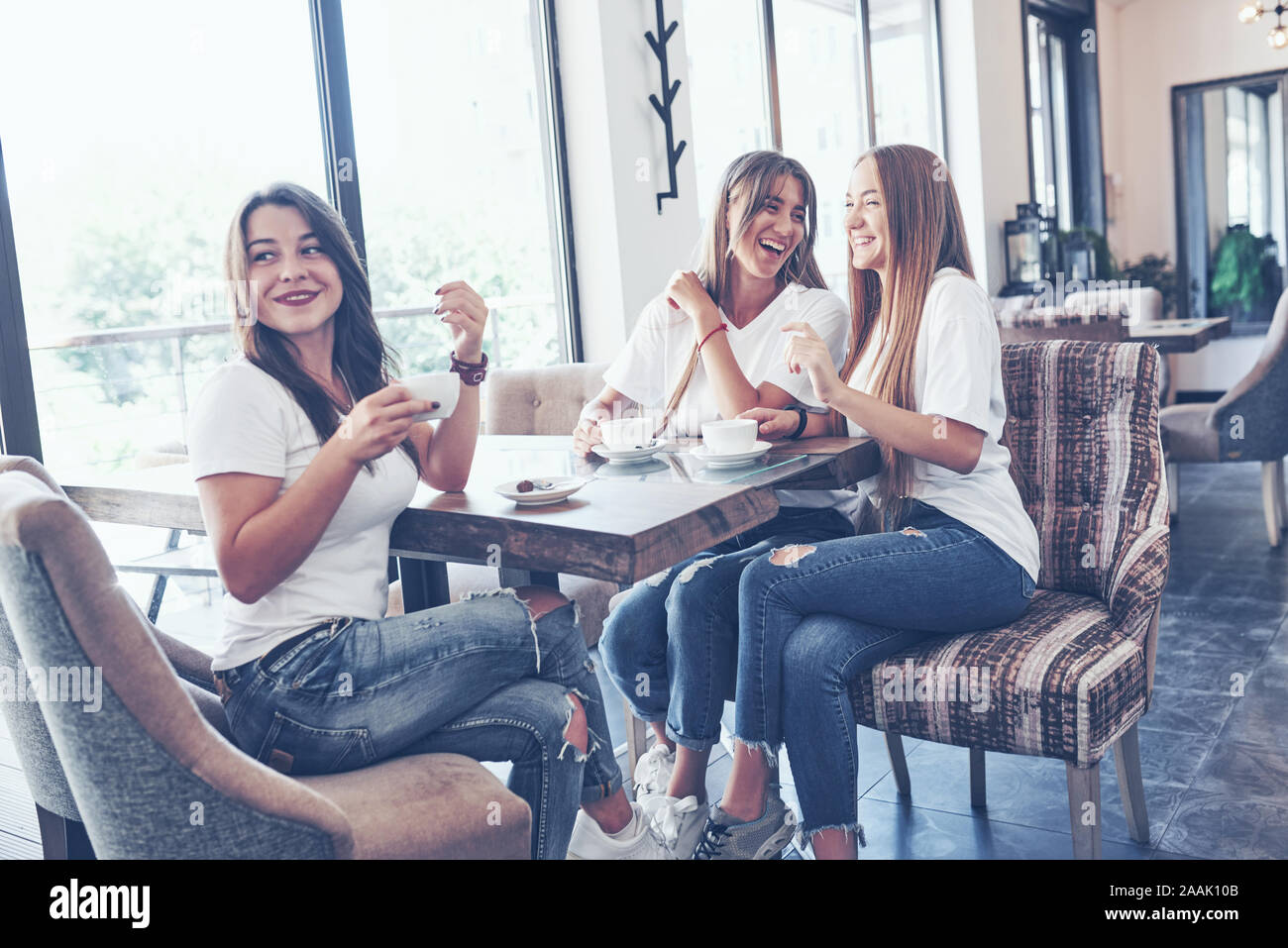 The three best girlfriends gathered to drink coffee and gossip. Girls ...
