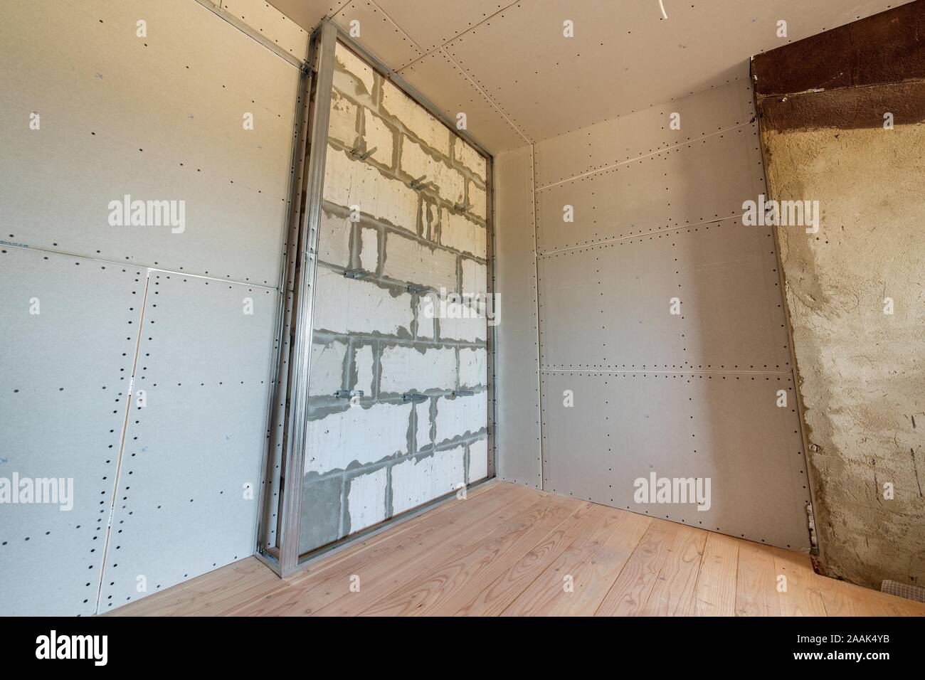 Unfinished brick wall in a room under construction prepared for drywall ...