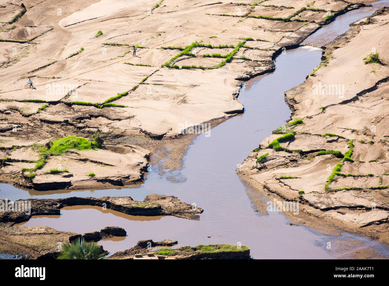 Farmland destroyed by the floods, with local farmers crossing their ...