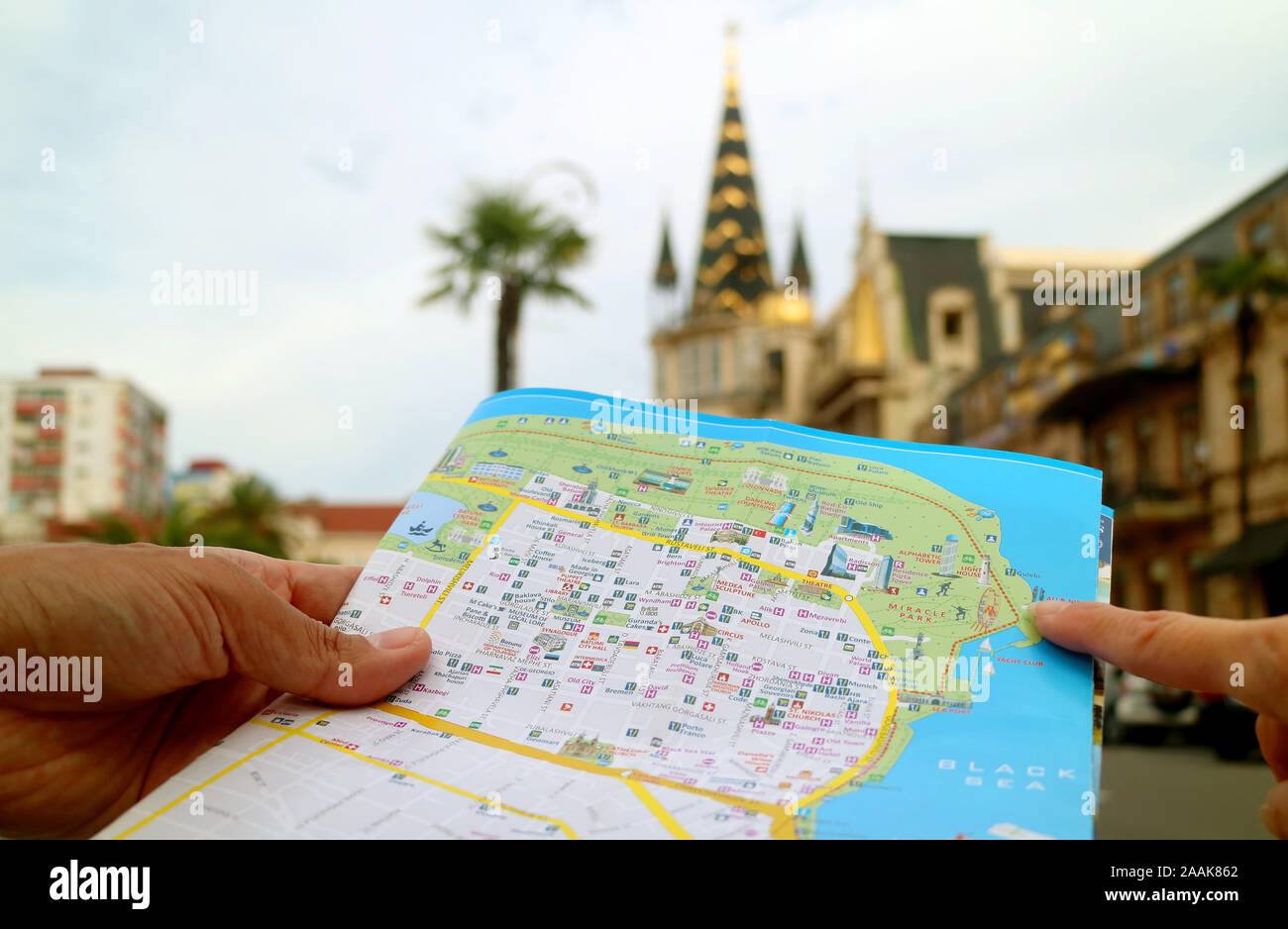 Finger Pointing at Batumi City Map with Blurry Astronomical Clock Tower ...