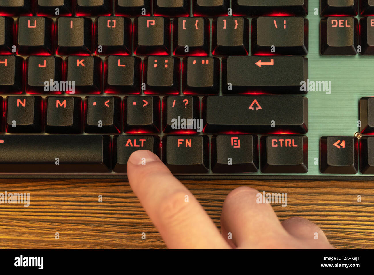 male hand presses alt key on black keyboard with red backlight Stock ...