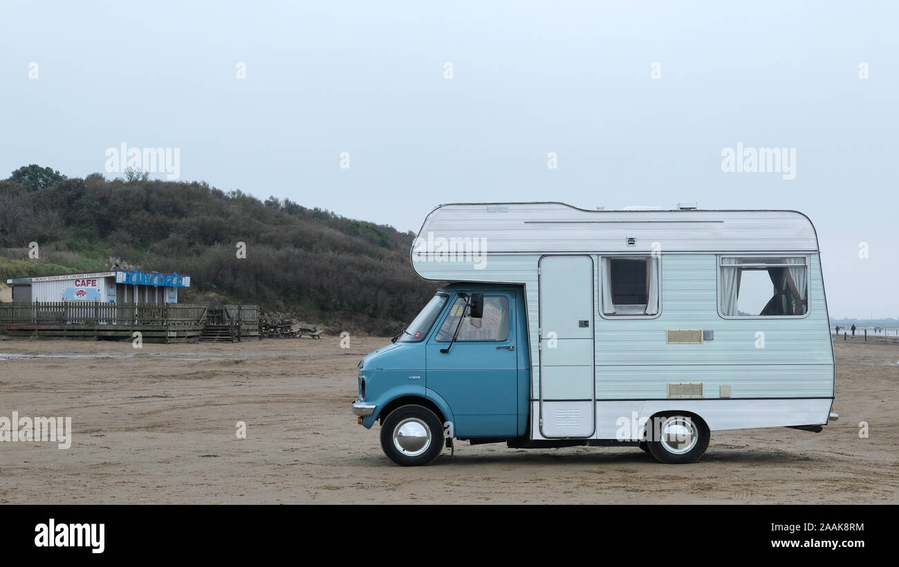 A classic Bedford Camper van parked up on a beach in an English seaside ...
