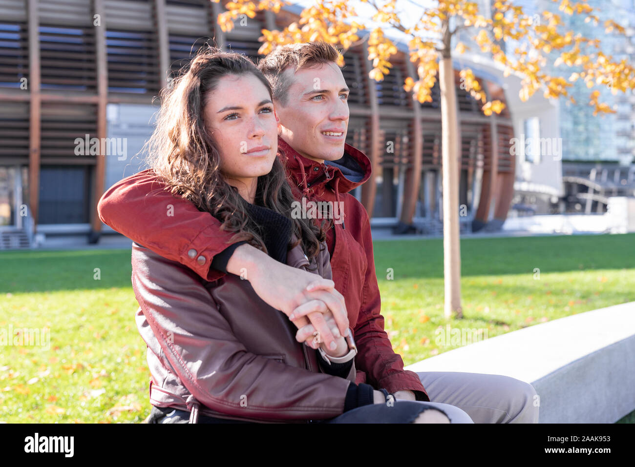 two young lovers sitting on a bench hugging each other tenderly Stock ...