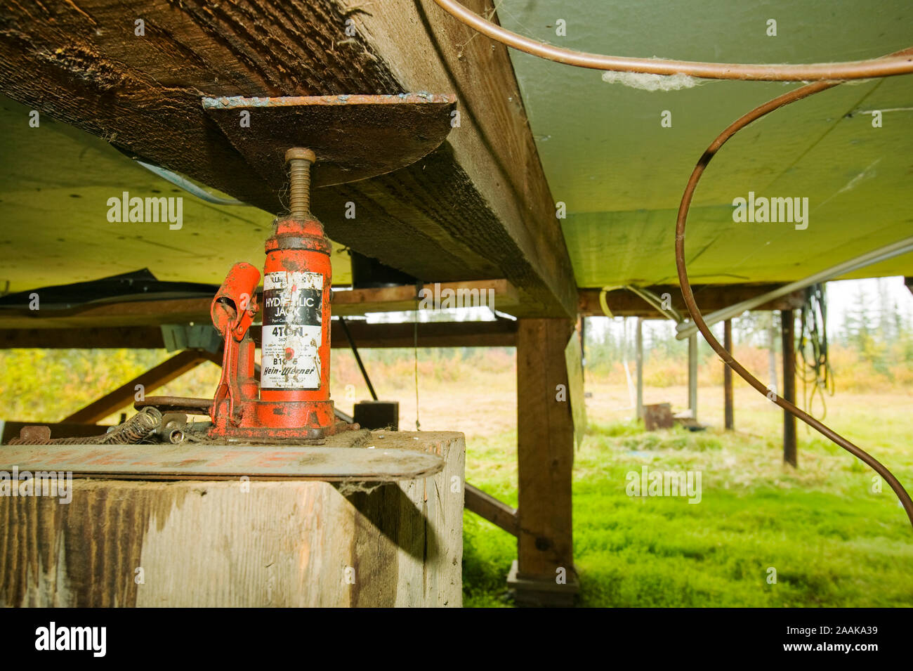 A desperate householder uses a jack to try and keep their house level ...