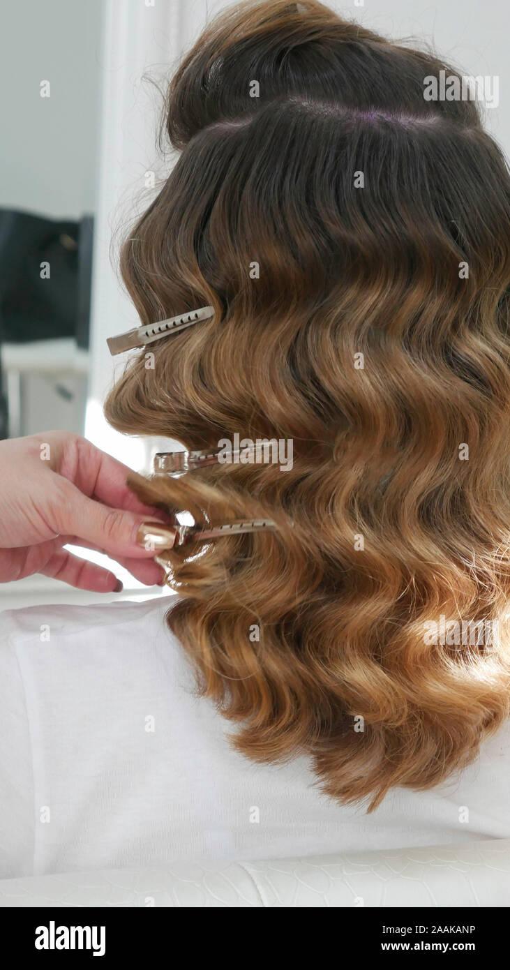 Hairdresser's hands putting clasps in a client's hair Stock Photo - Alamy