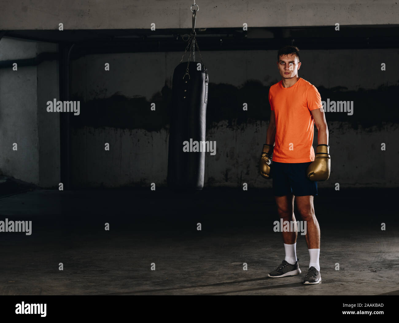 Muscular handsome fighter giving a forceful forward kick during a ...