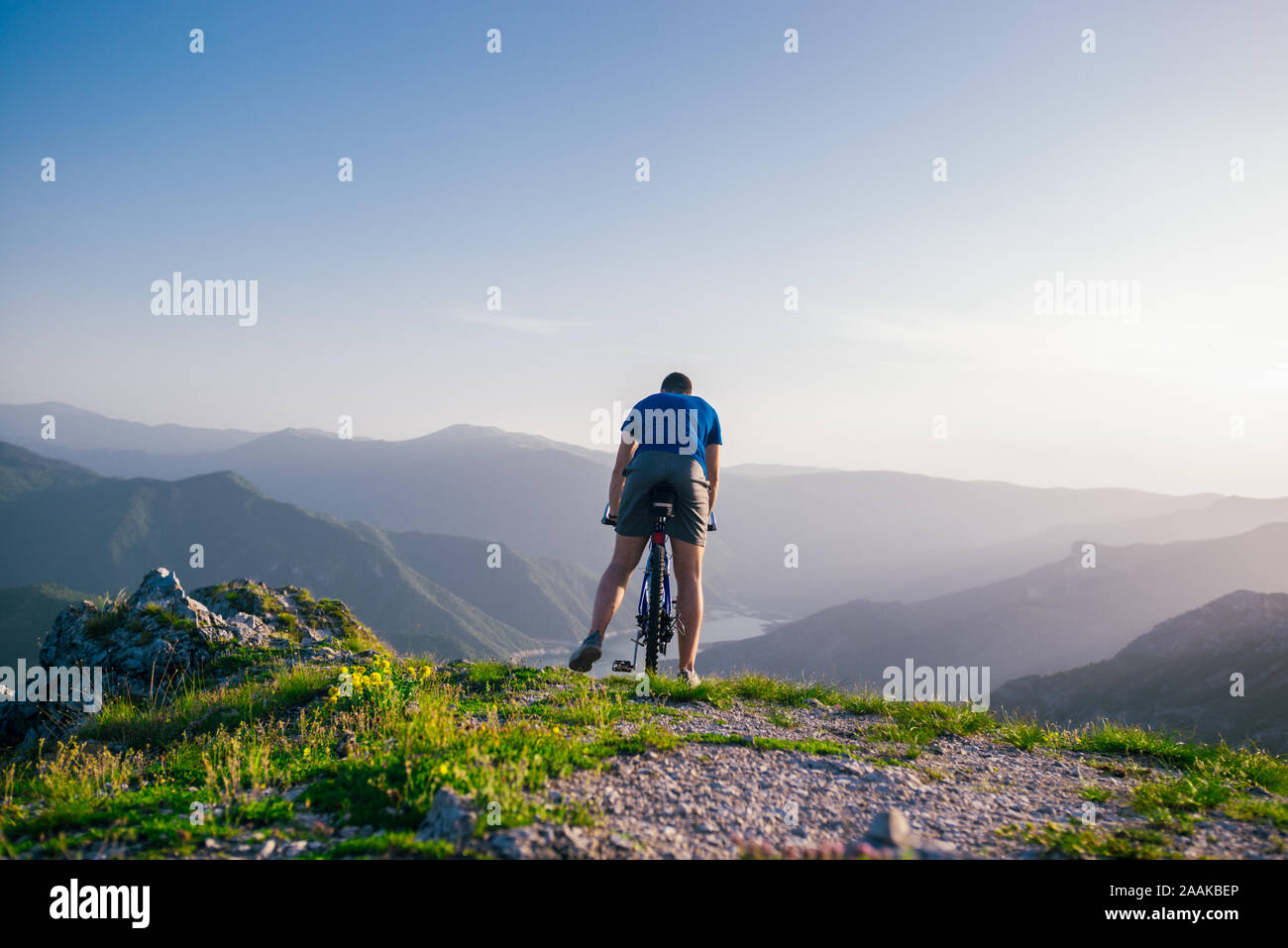 Adventurous Cyclist riding his mountain bike at the edge of a cliff, on ...