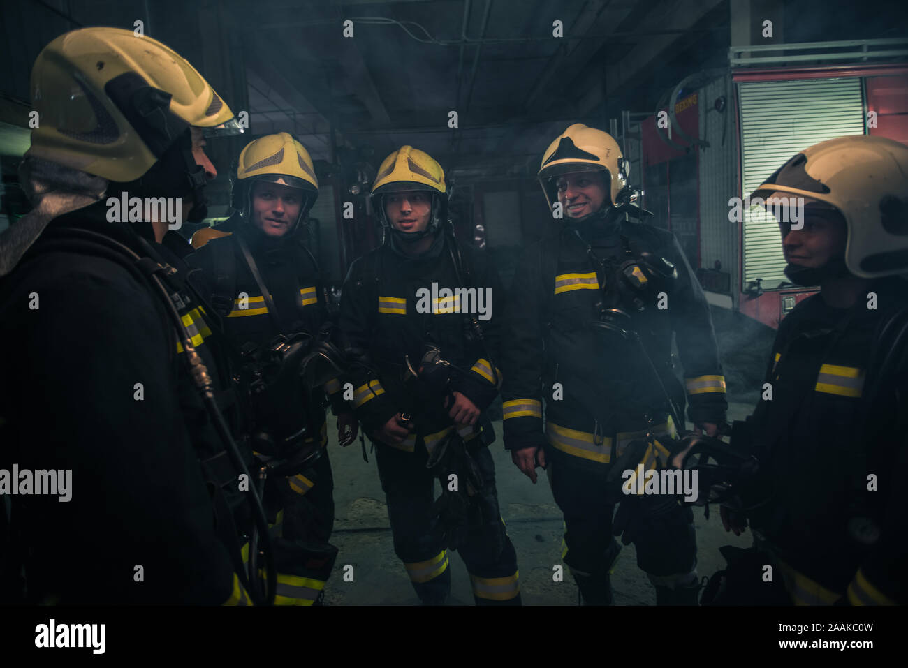 Team of firefighters standing inside ( indoors ) a buliding next to a ...