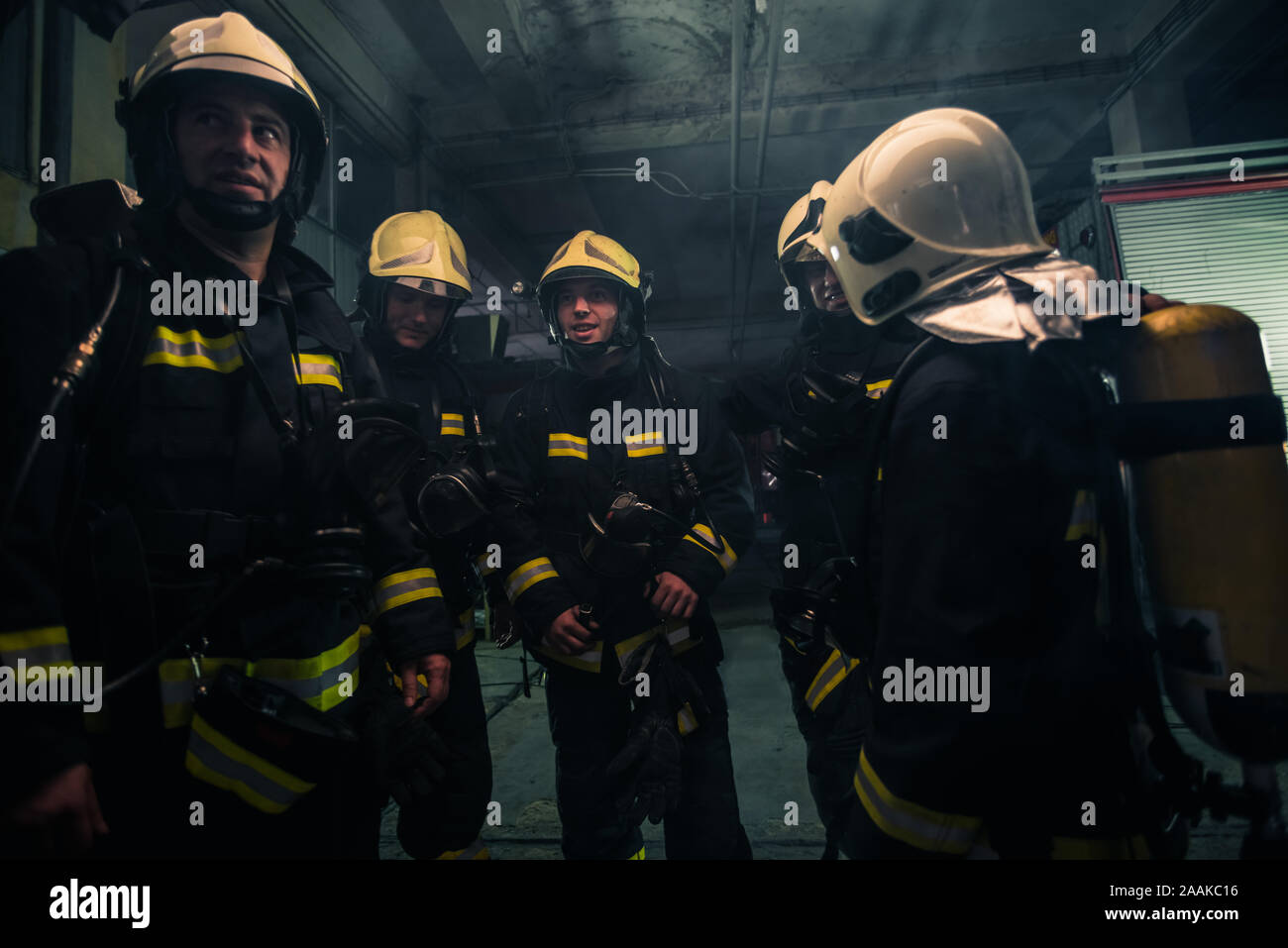 Team of firefighters standing inside ( indoors ) a buliding next to a ...