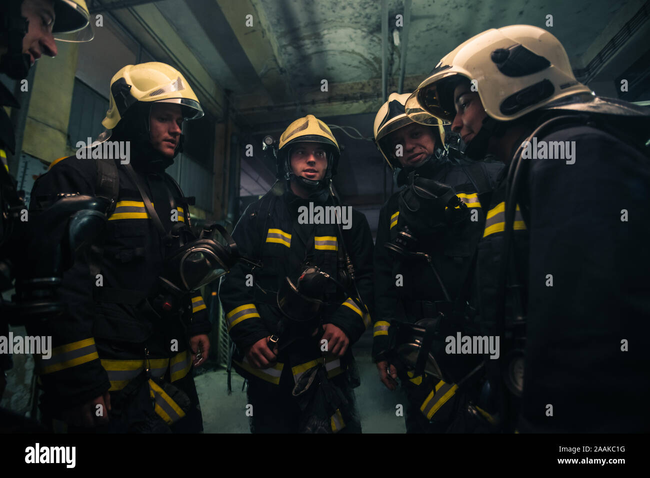 Team of firefighters standing inside ( indoors ) a buliding next to a ...