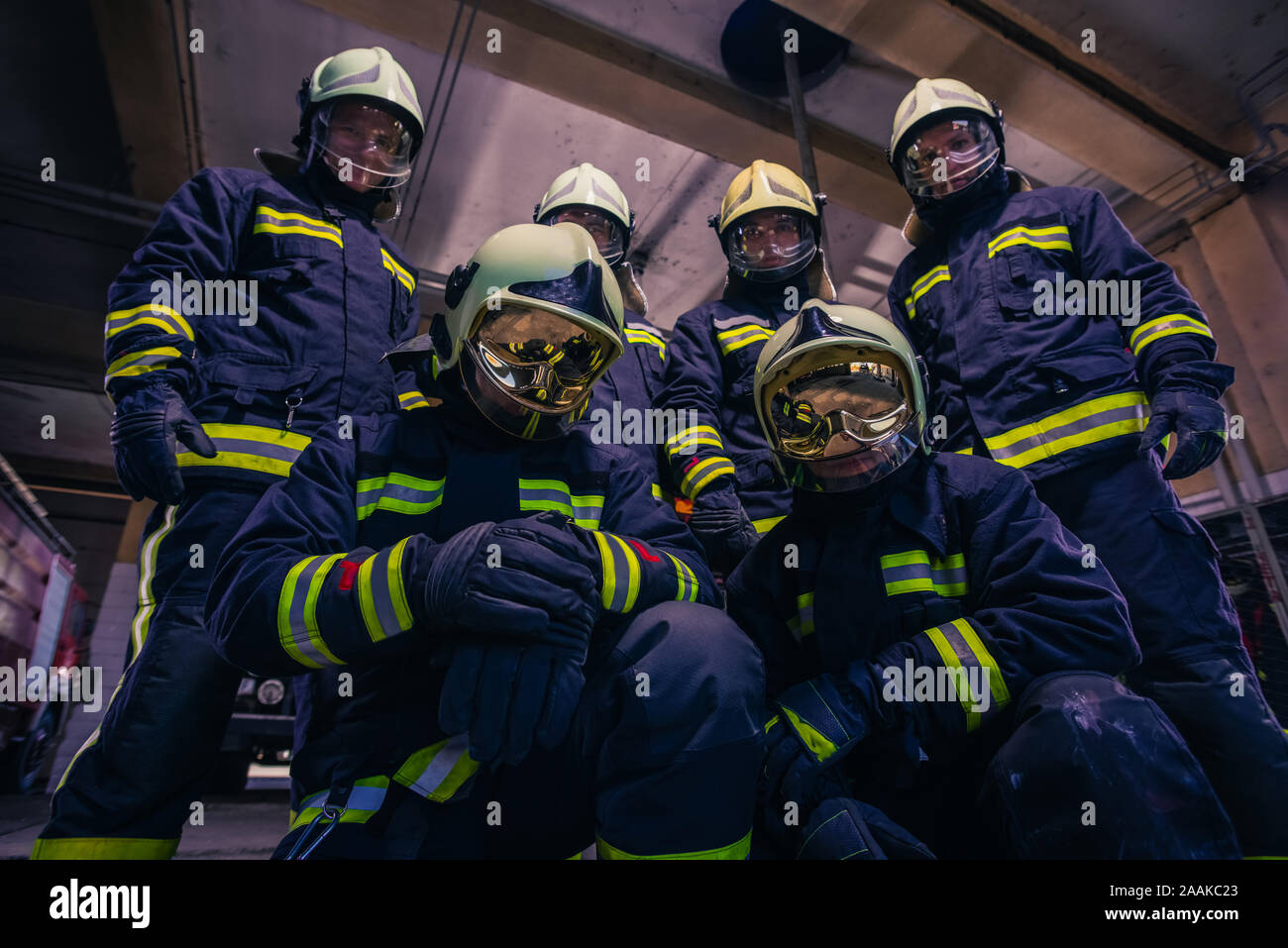 Portrait of group of firefighters wearing protective uniform inside the ...