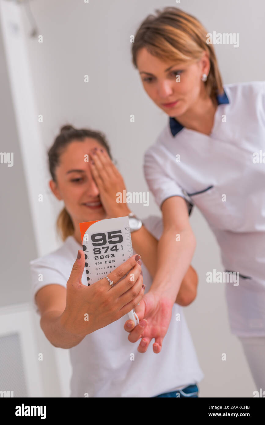 Woman ( girl )reviewing eyesight closing eye with hand. Eye test ...