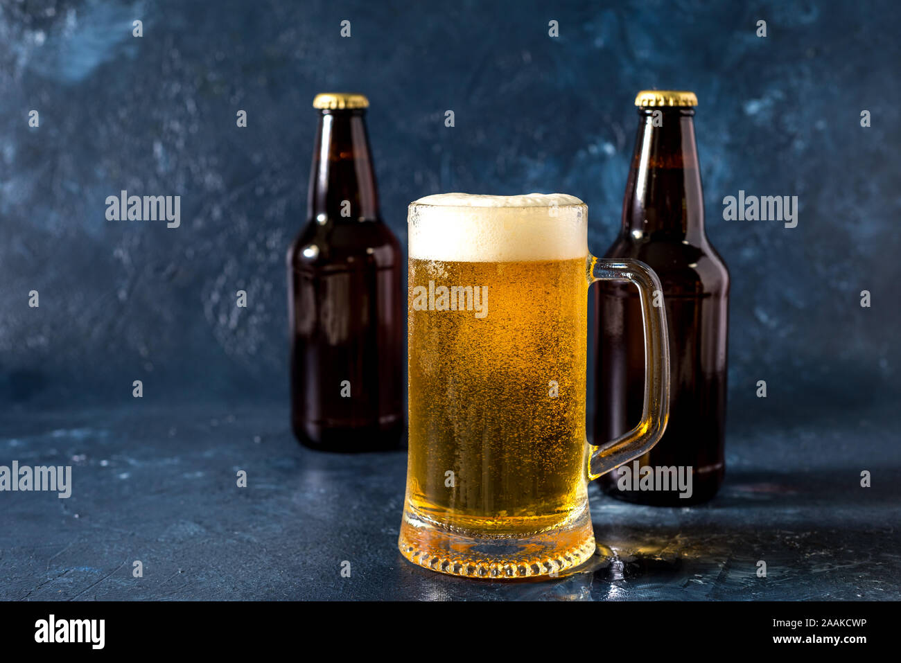 glass of cold beer and bottle on gray stone table Stock Photo - Alamy