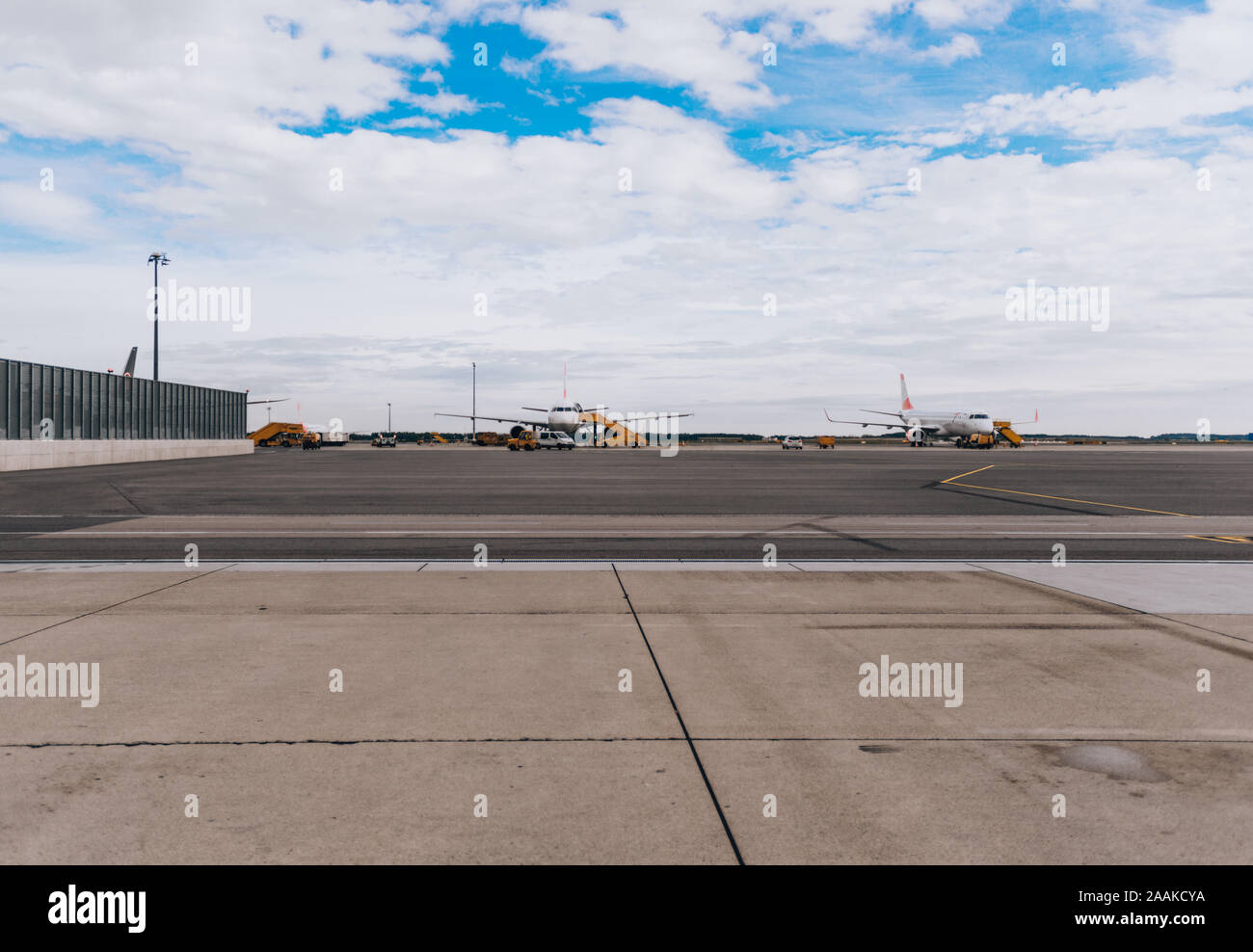 Two big airplanes on a concrete runway with passenger boarding stair ...