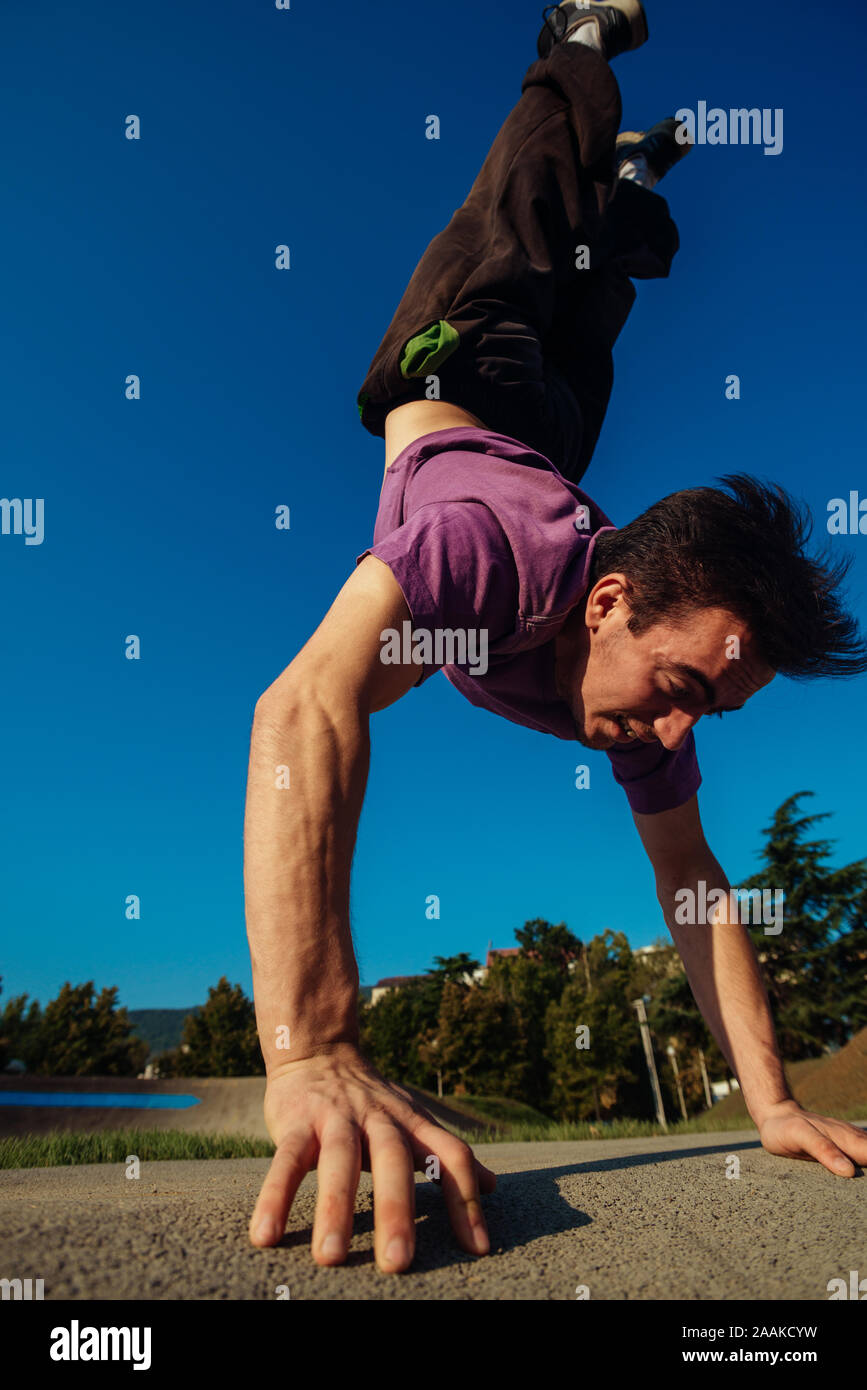 Athletic guy during a handstand exercise at a city skatepark Stock ...