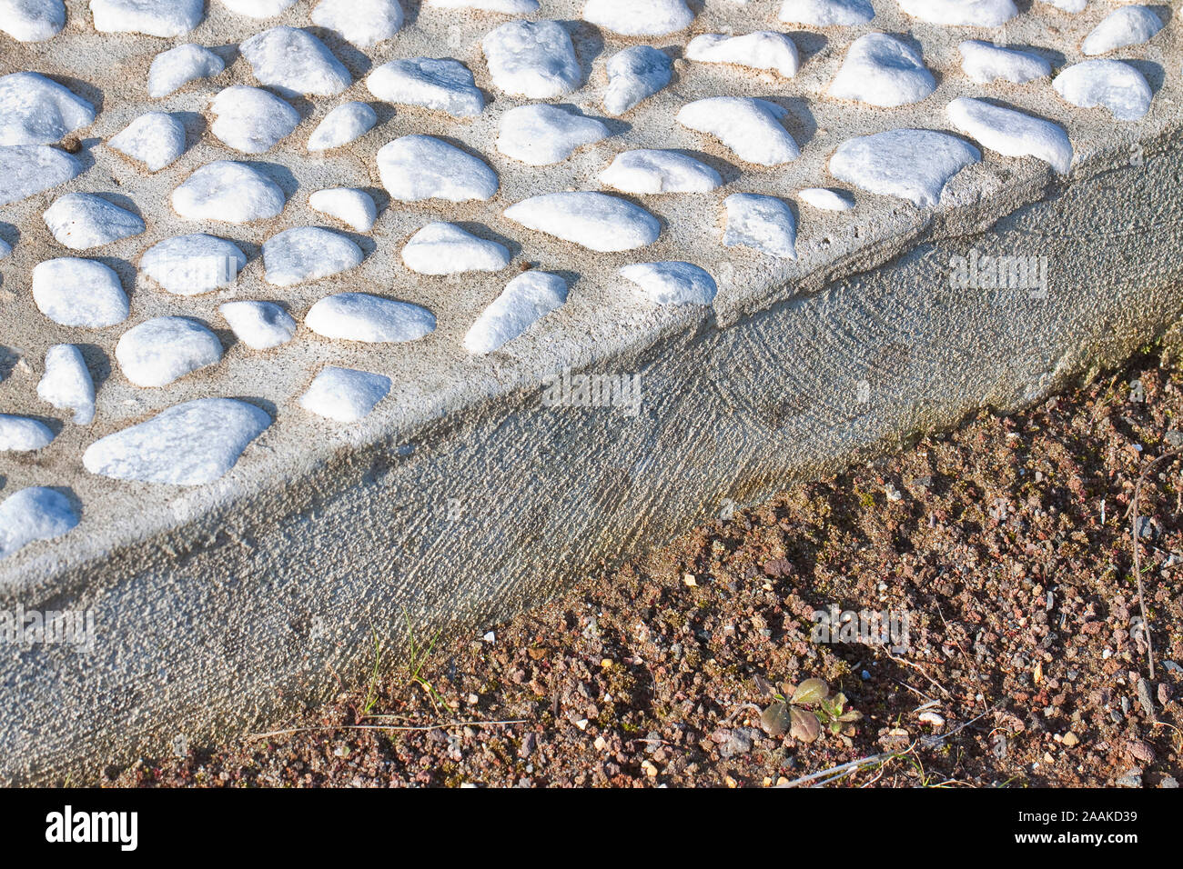Construction of a stone pebble pavement with a white rounded stone ...