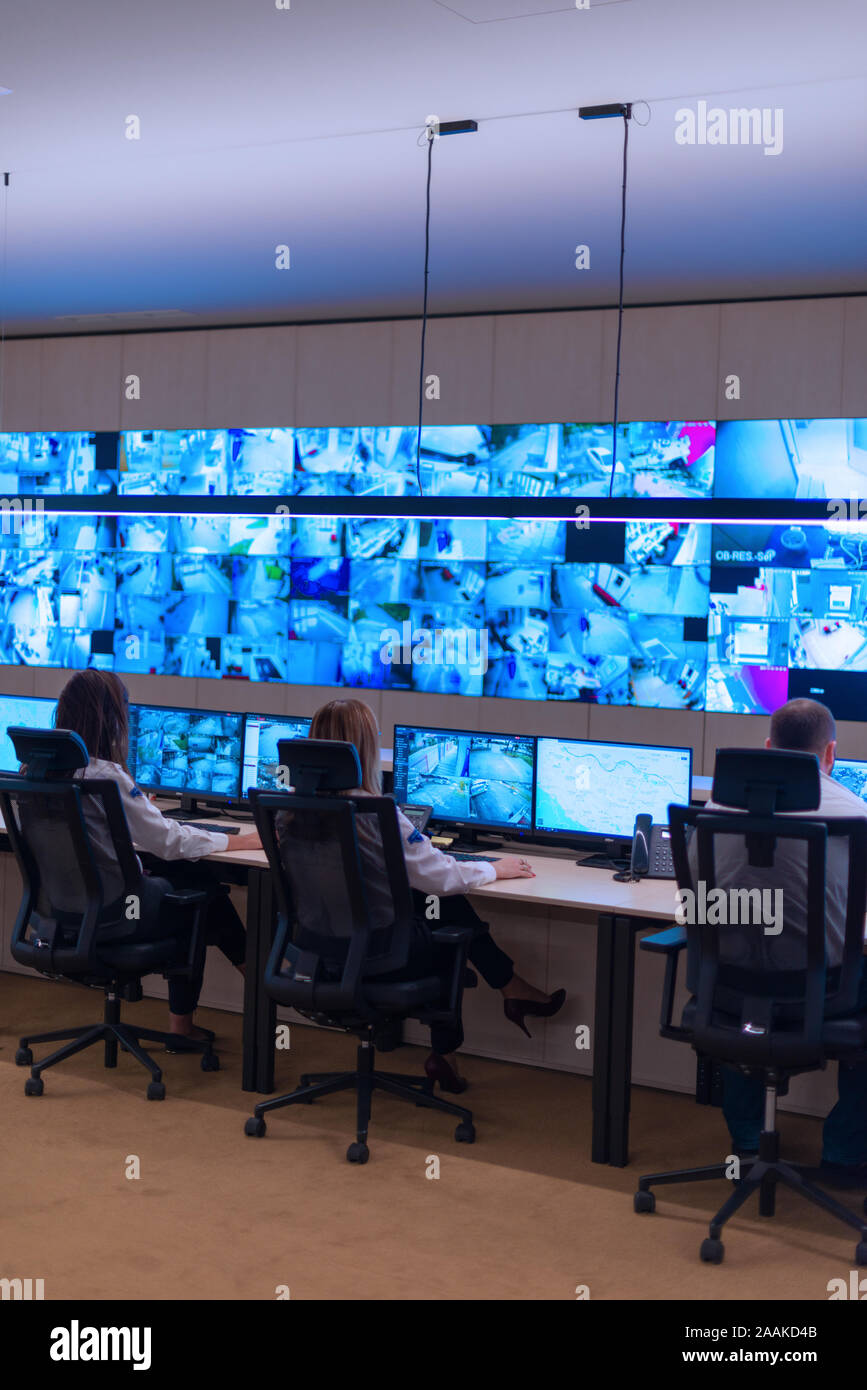 Female security guards working on computers while sitting in the main ...