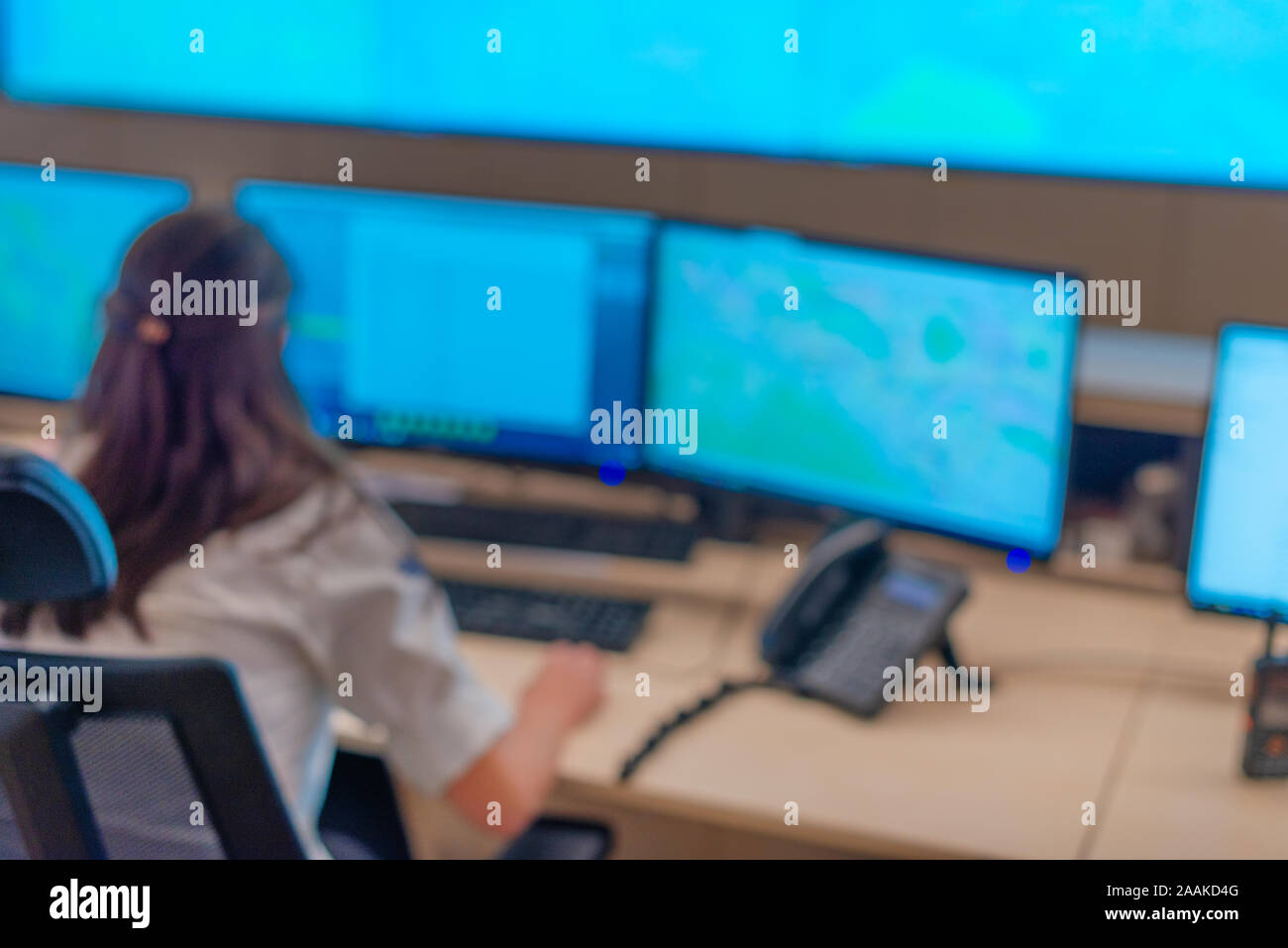 Blurred photo of security guards working on computers while sitting in ...