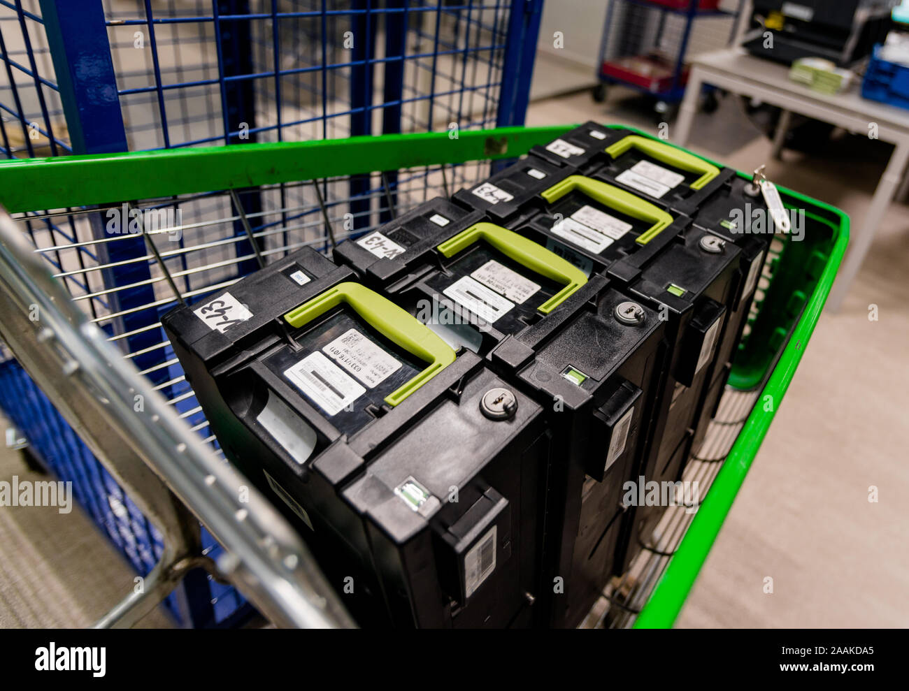 Four safety boxes full of counted cash placed in a cart for ...