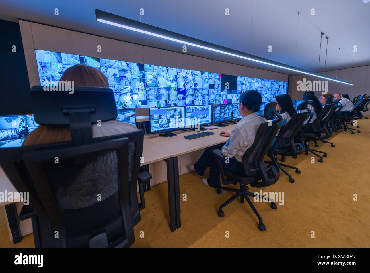 Female security operator working in a security data control room ...