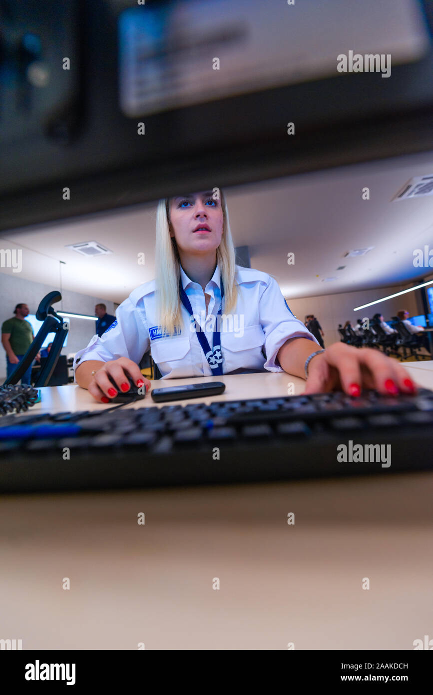Female security operator working in a security data control room ...