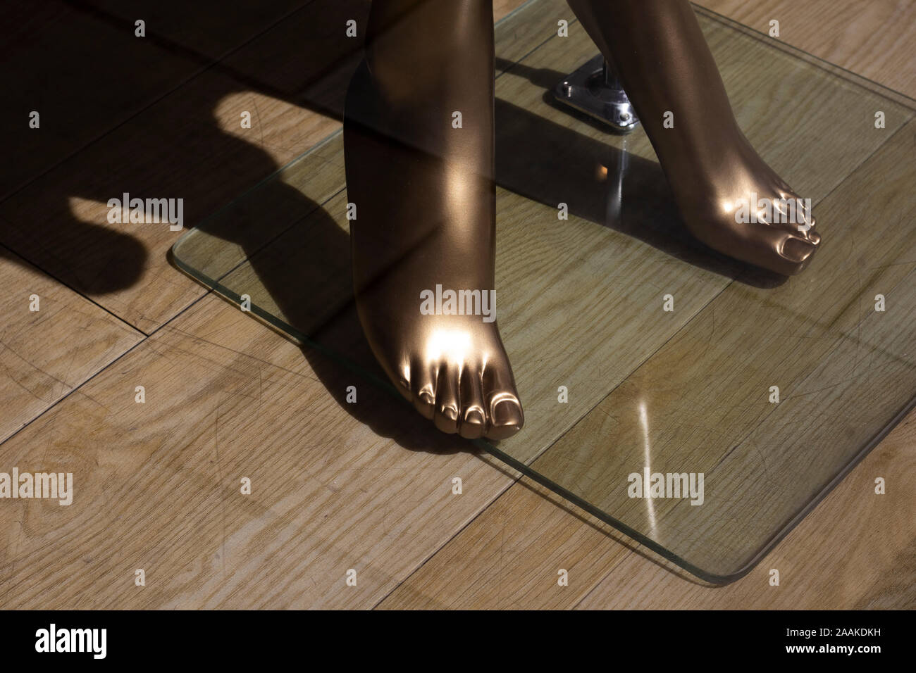 gold manikin feet in ladies fashion shop window display Stock Photo - Alamy