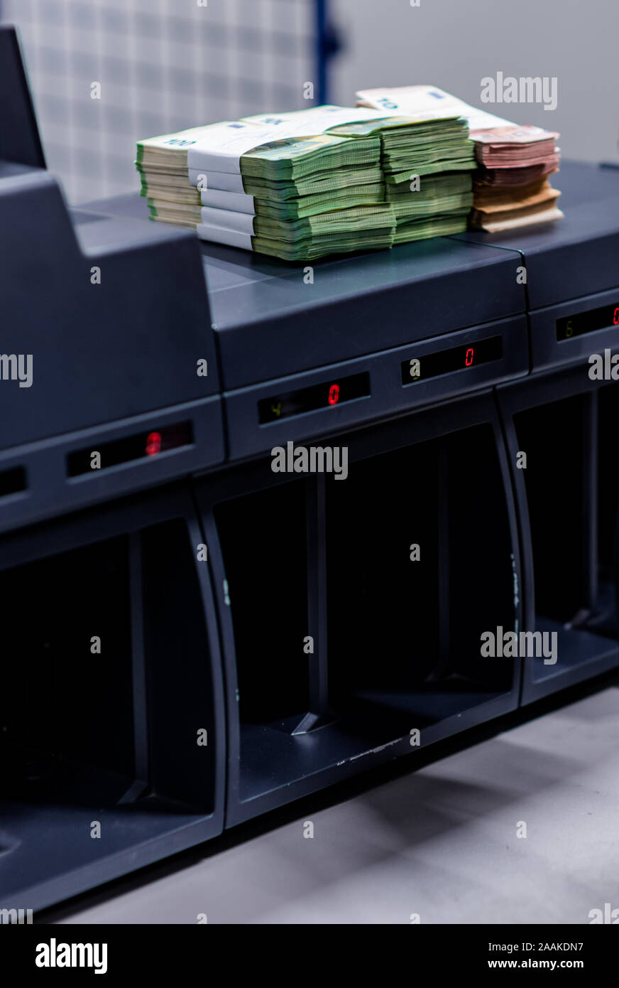 Accountant placing banknotes that are bundled with currency straps into ...