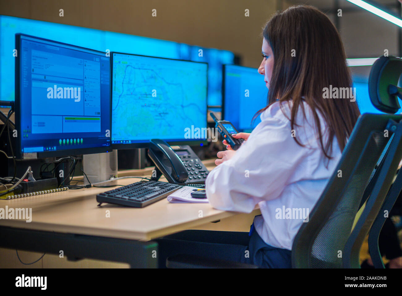 Female security guard sitting and monitoring modern CCTV cameras in a ...