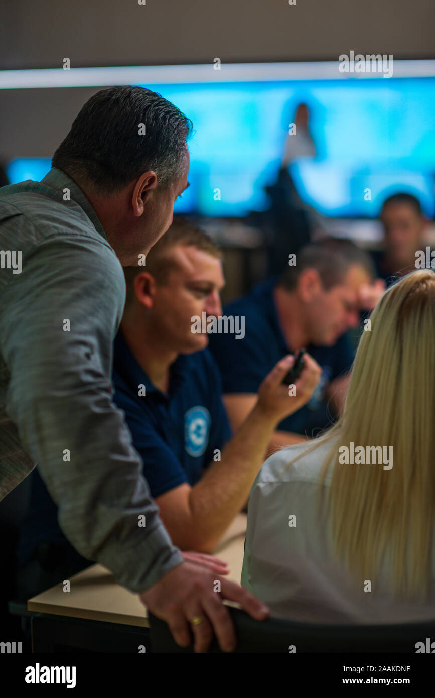 Security guard monitoring modern CCTV cameras in a surveillance room ...