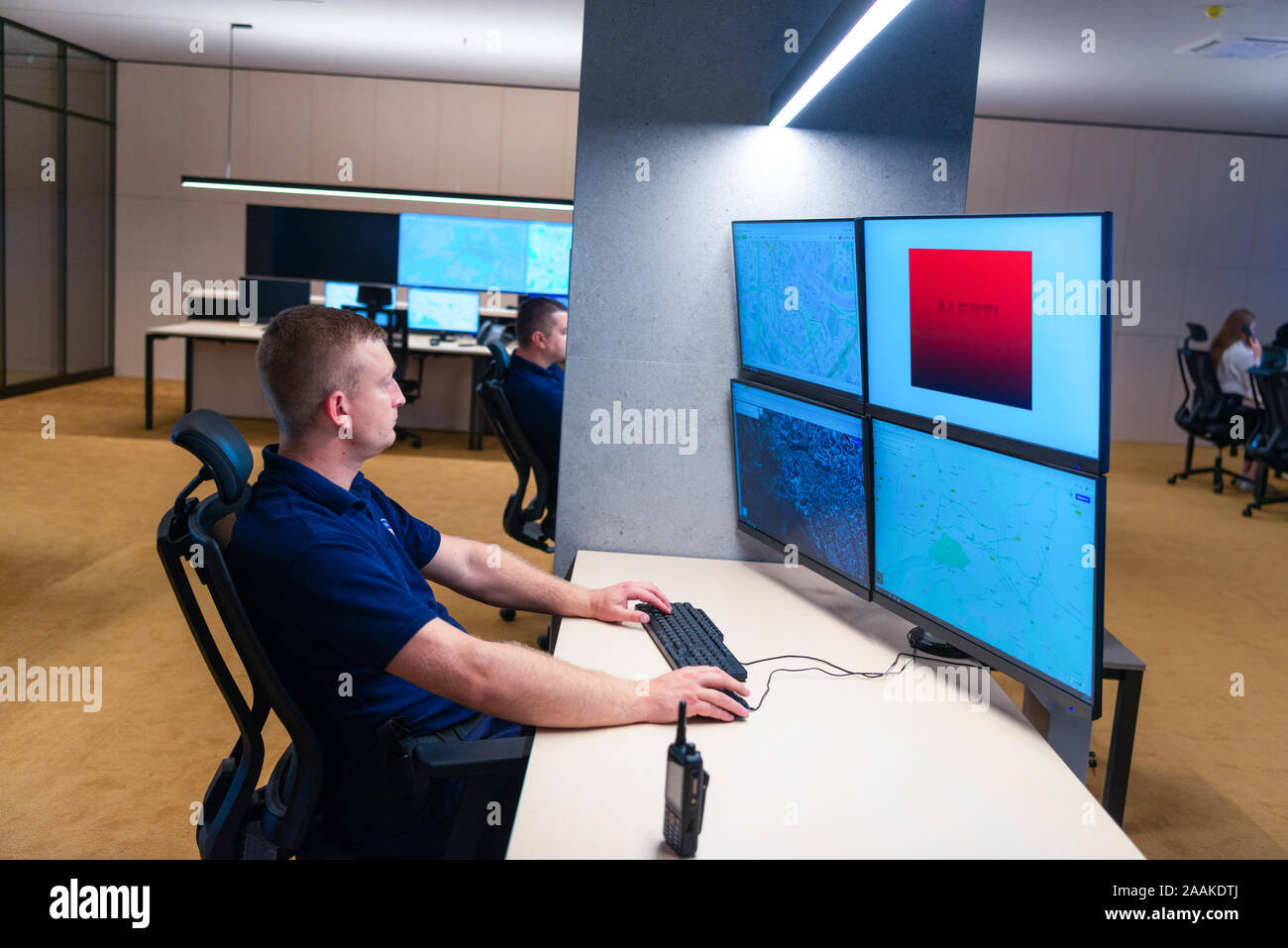 In the Security Control Room Officer Monitors Multiple Screens while ...