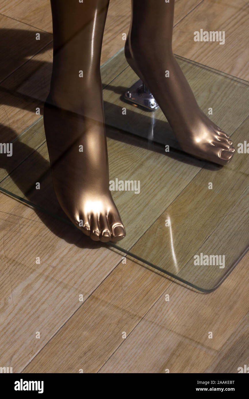 gold manikin feet in ladies fashion shop window display Stock Photo - Alamy