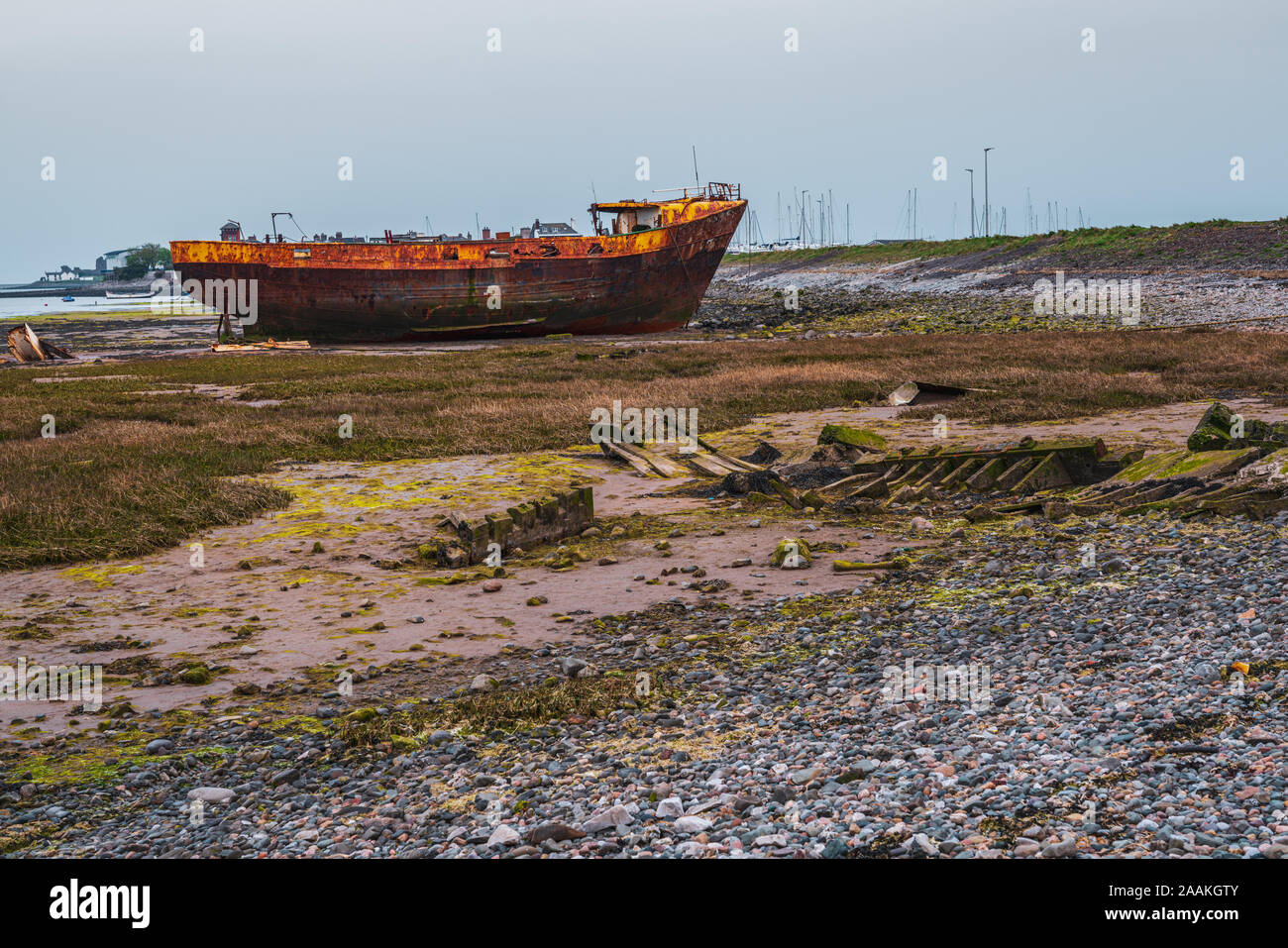 A rusty shipwreck in the mud of the Walney Channel, seen from the road ...
