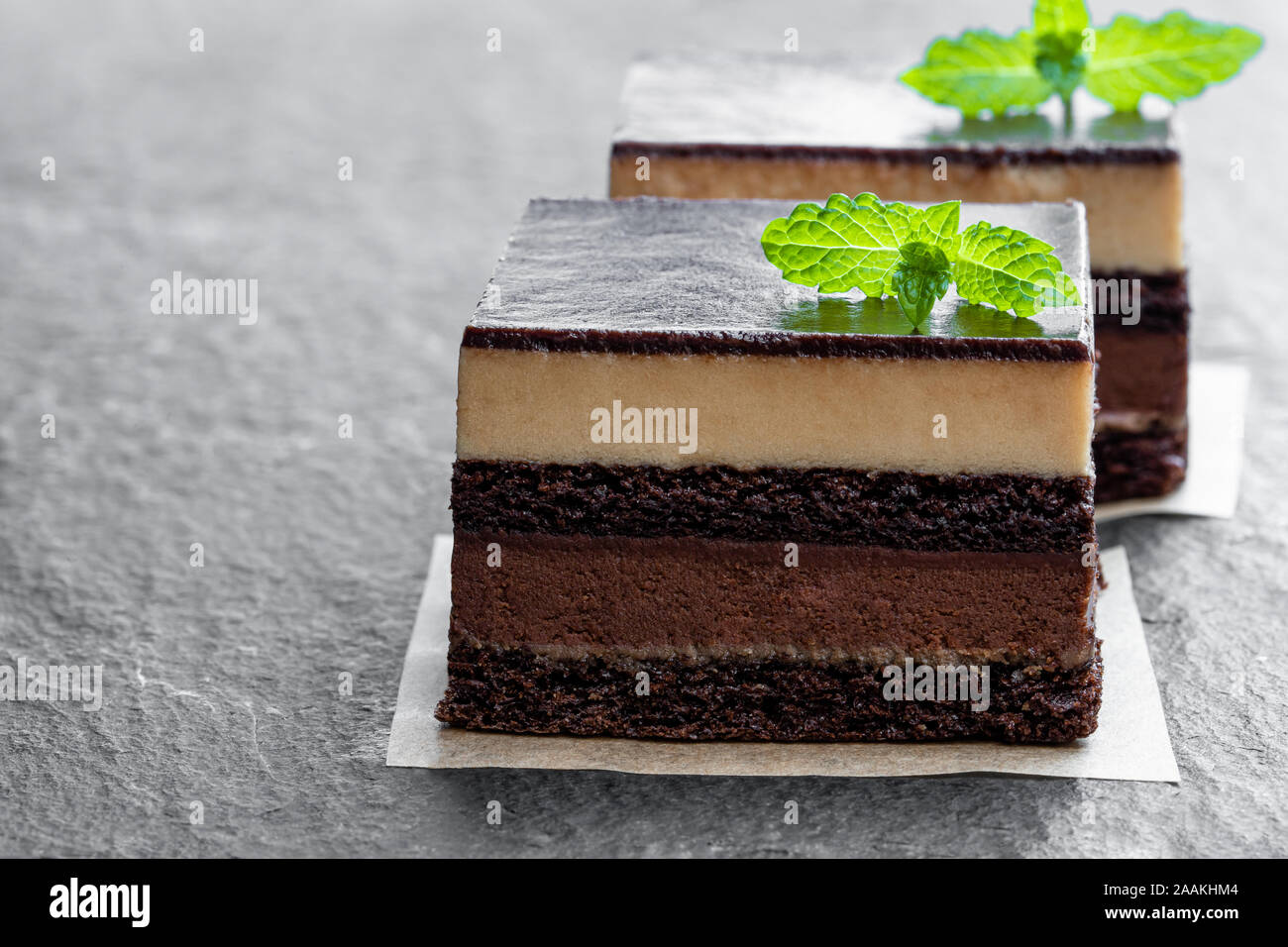 Chocolate and coffee cake slices on black stone background Stock Photo ...