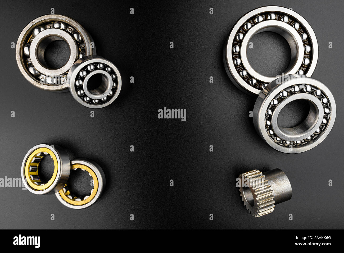 Ball bearing lying on a black background with copy space in the middle ...