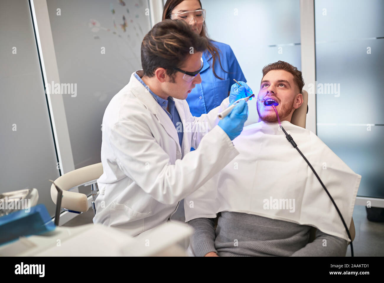 Young smiling man at the dentist.Dentists at work. Regular dentist ...