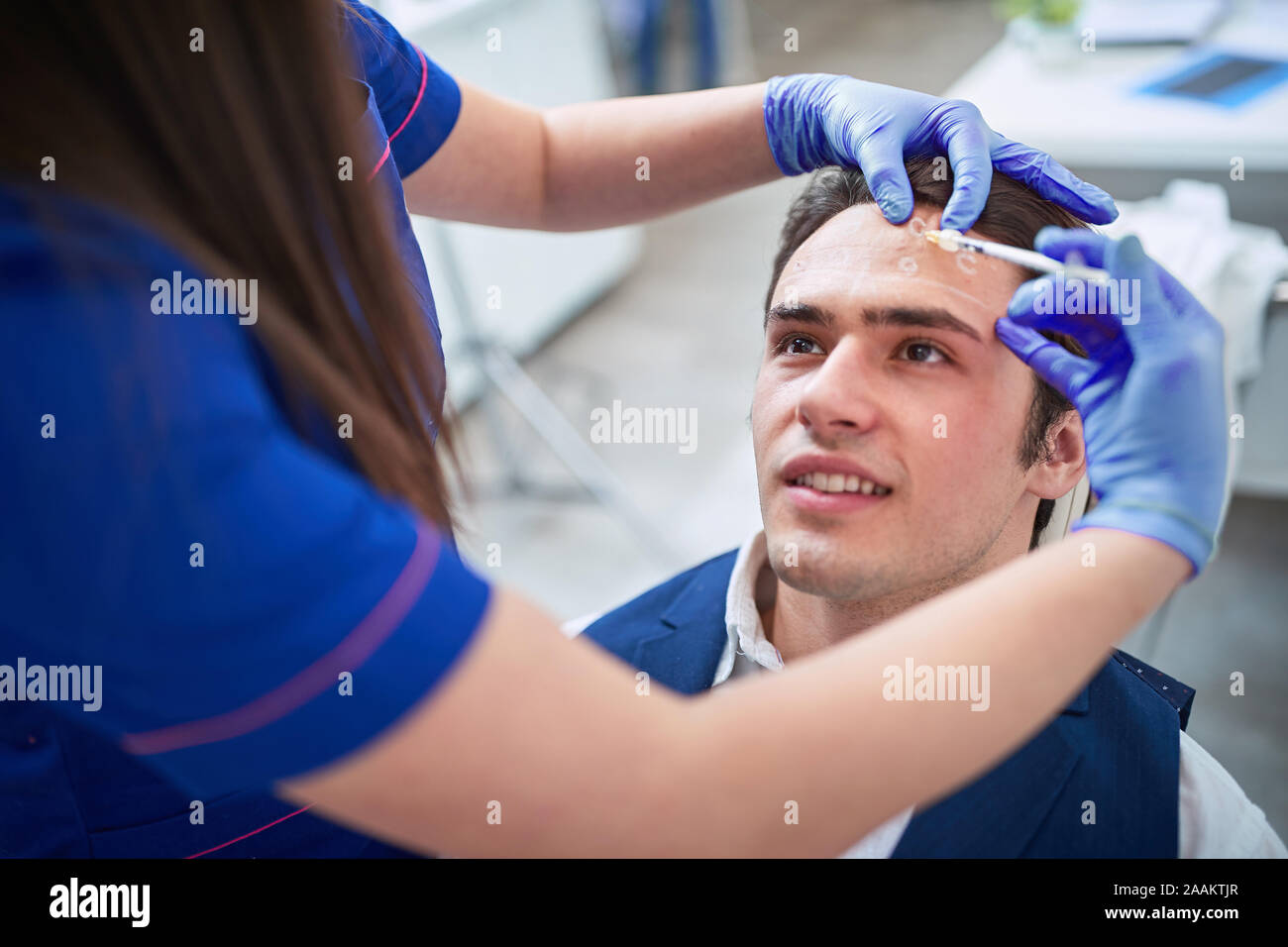 Smiling Man with markings on face getting a rejuvenating facial ...