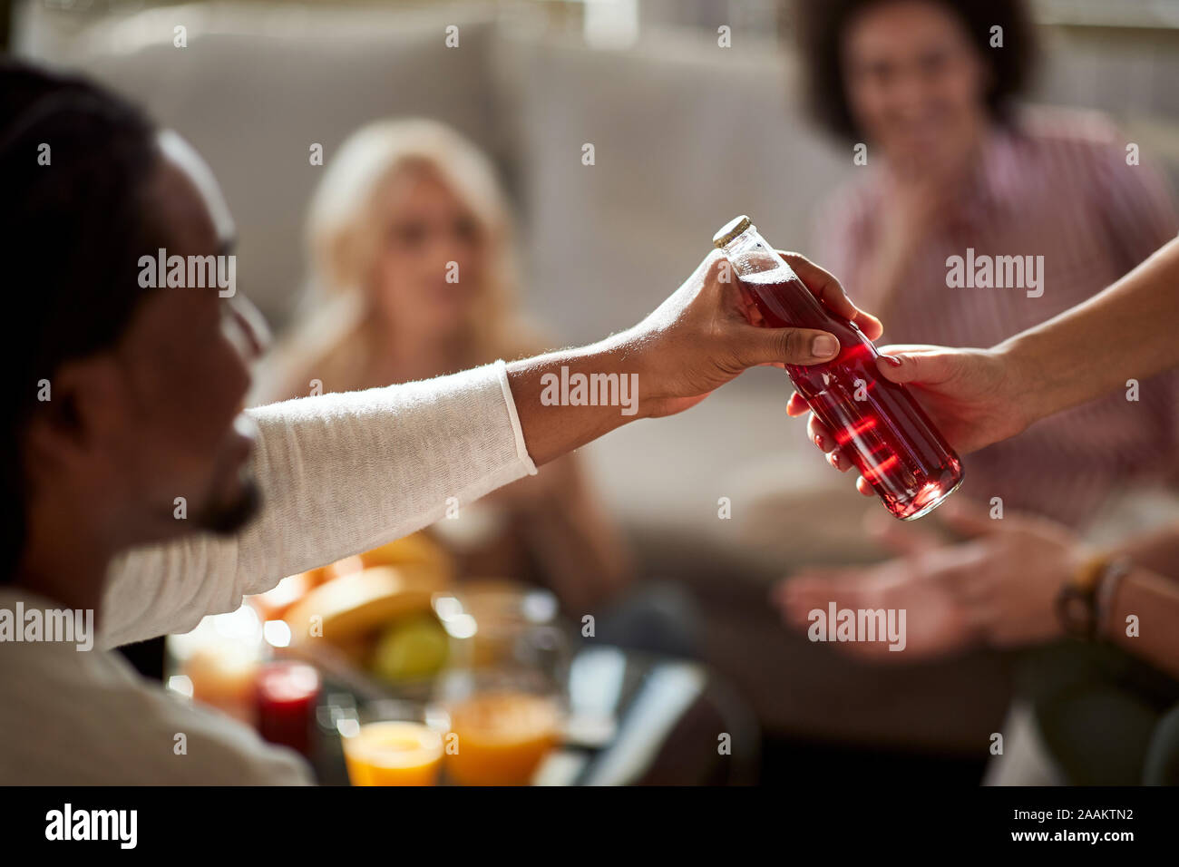 Male giving bottle with drink to female Stock Photo - Alamy