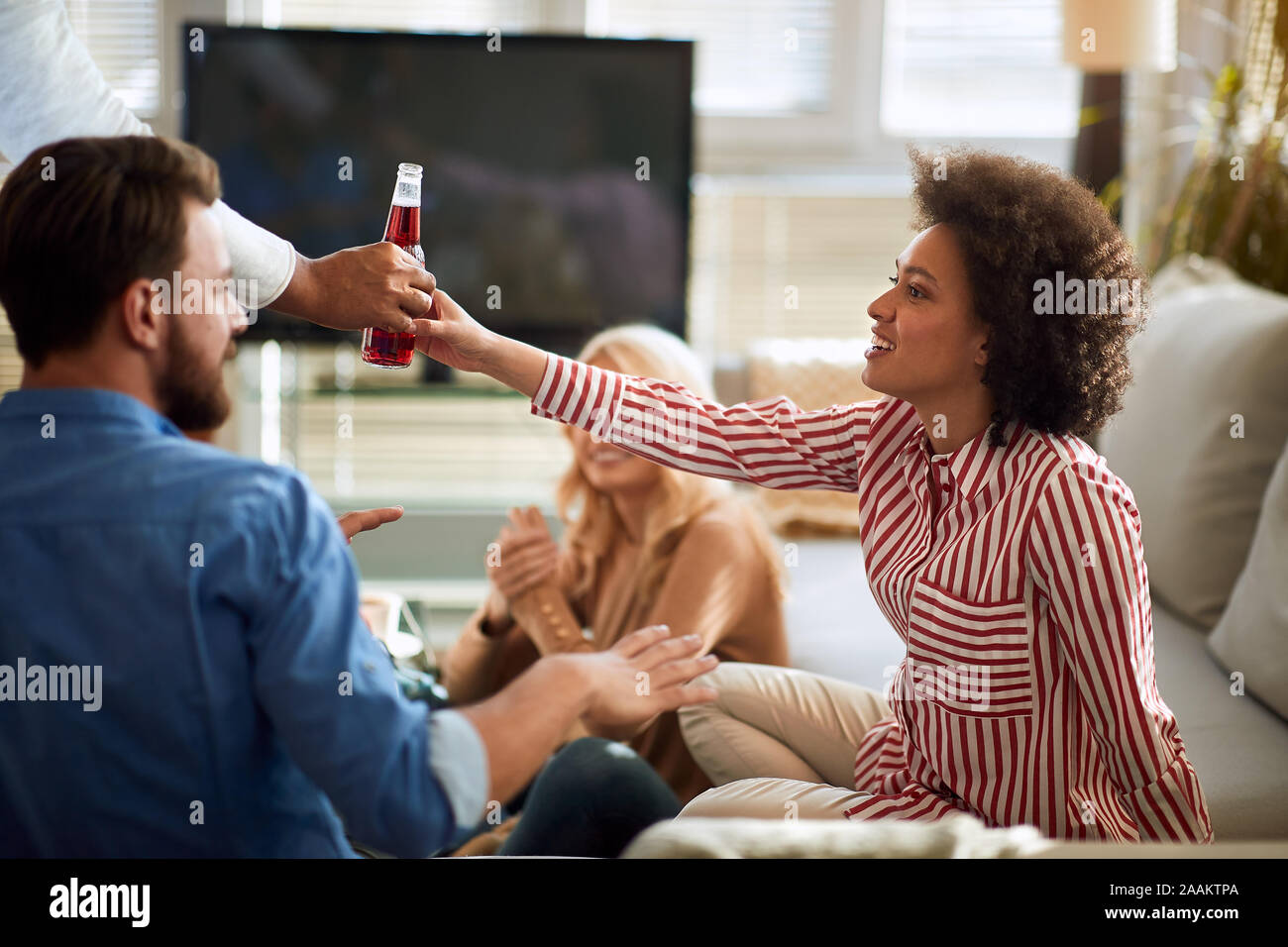 Young female taking drink from friend’s hand Stock Photo - Alamy