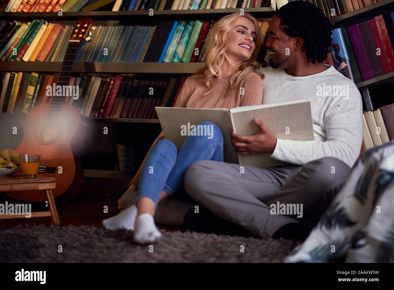 Smiling young couple reading a book together.Enjoying reading at home ...