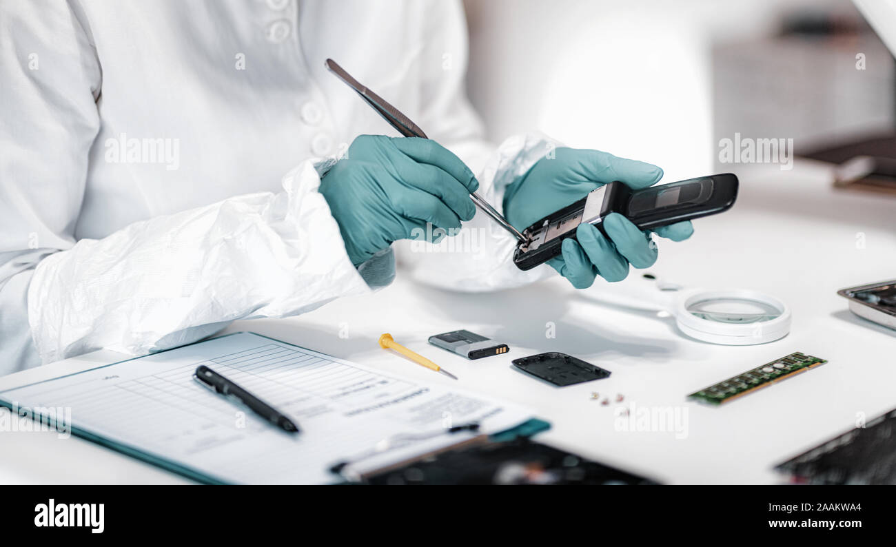 Digital forensic science. Police forensic analyst examining confiscated ...