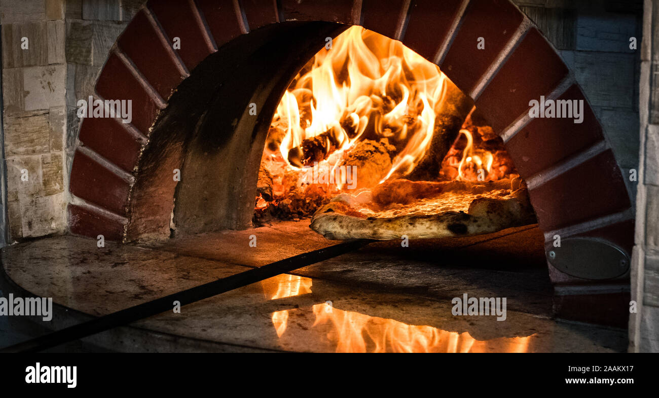 Pizza being removed from stone oven Stock Photo - Alamy