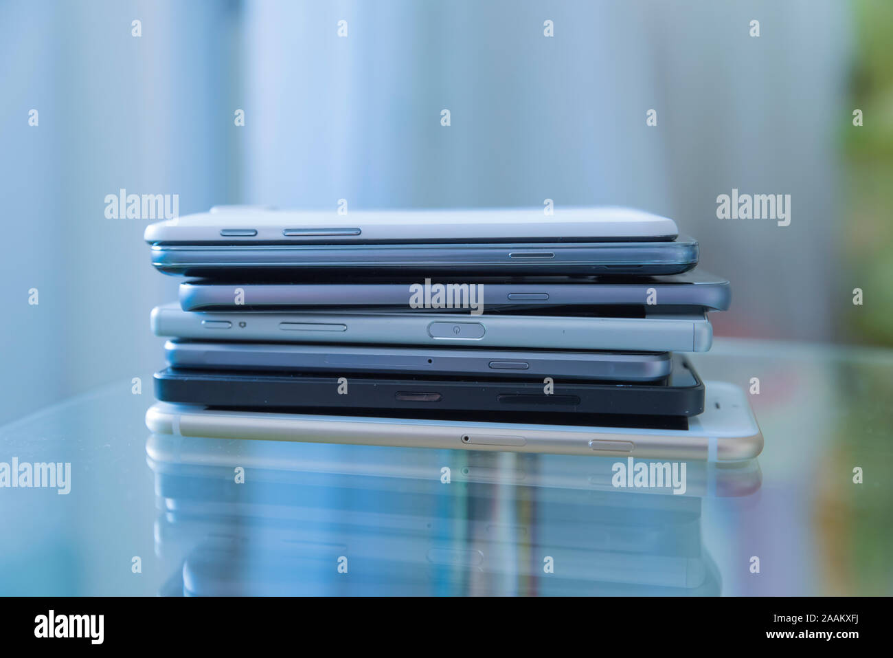 Smartphones arranged in pile stacked on top of each other placed on a ...