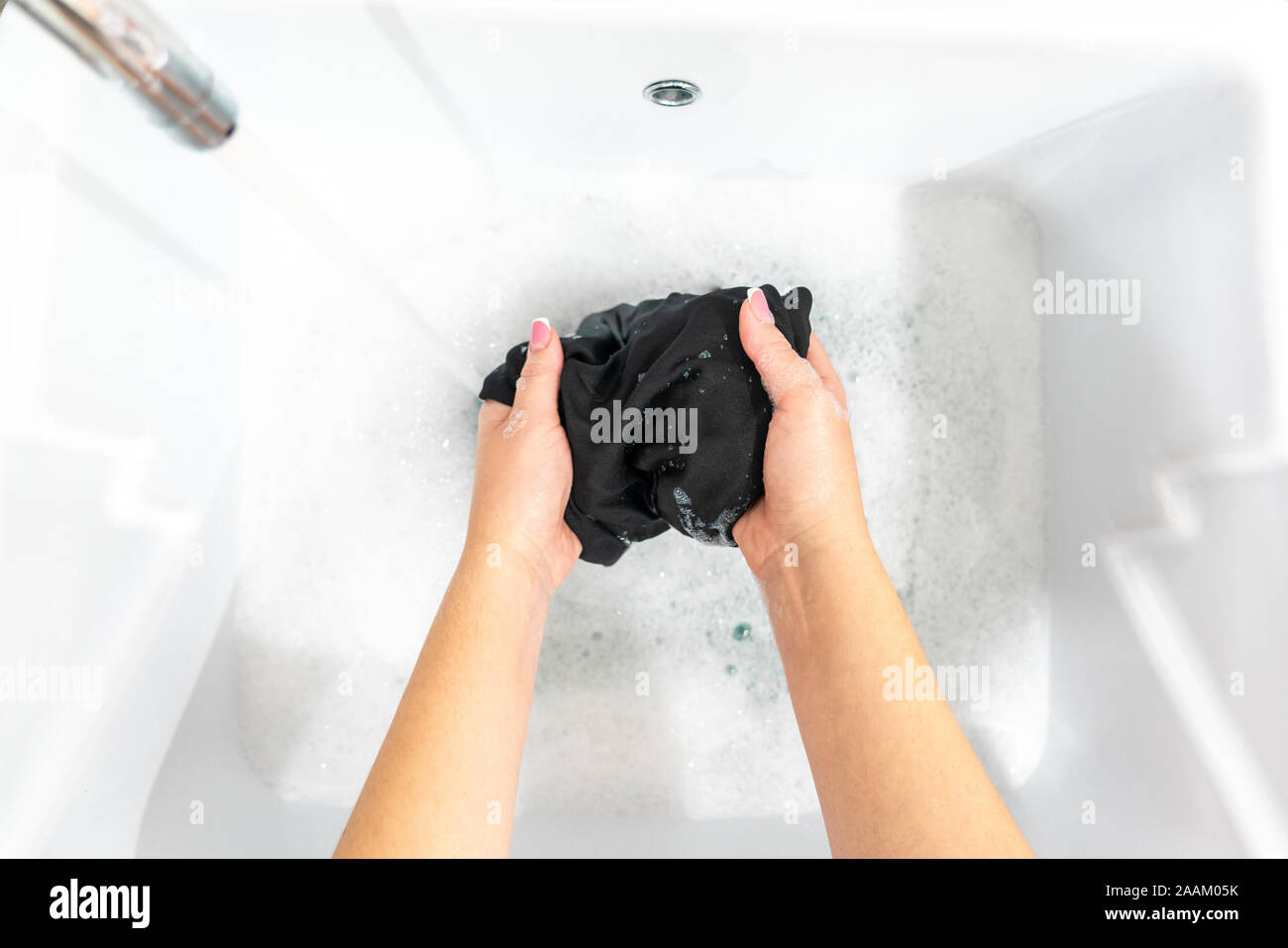 Female hands washing color clothes in basin Stock Photo - Alamy