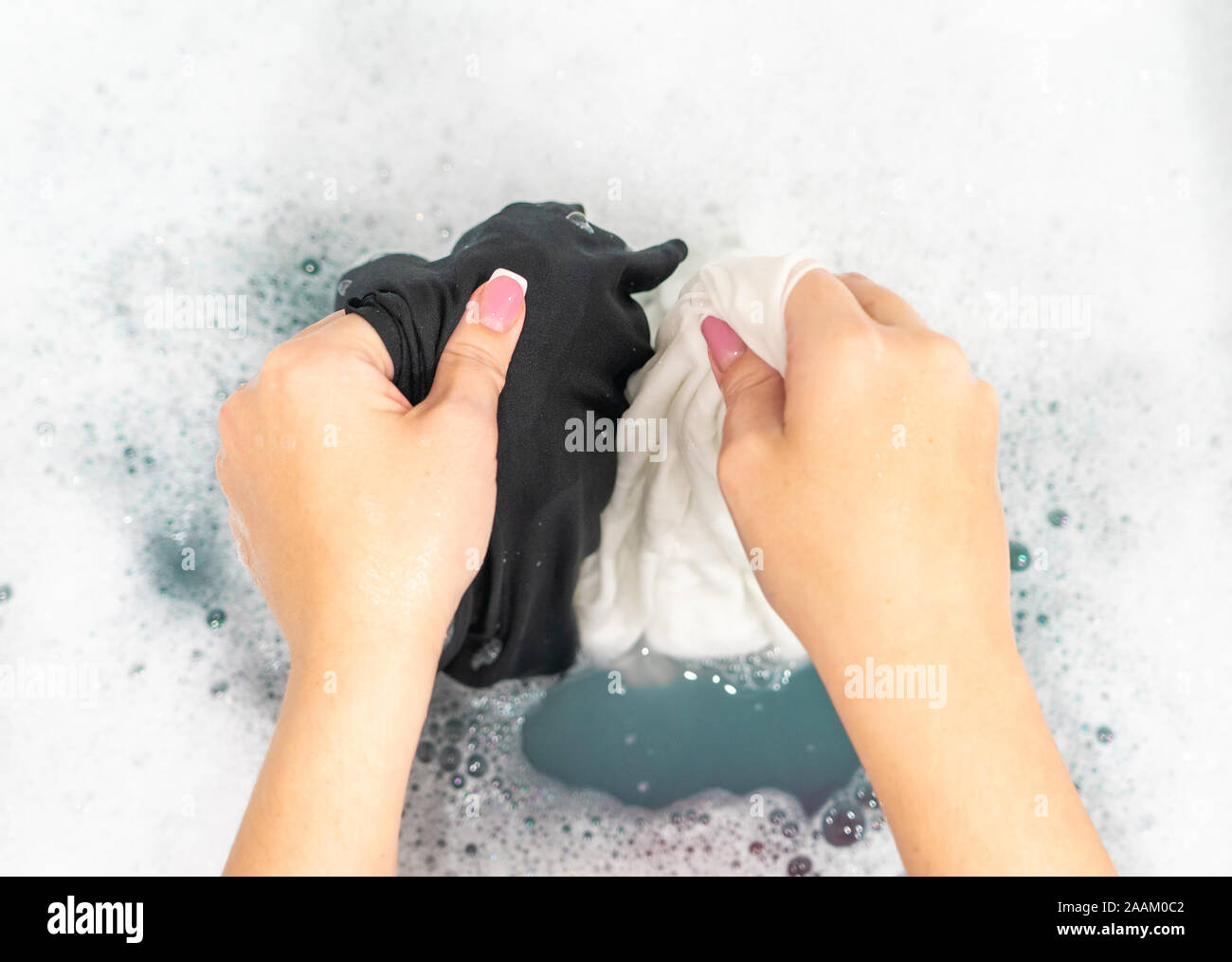 Female hands washing color clothes in basin Stock Photo - Alamy