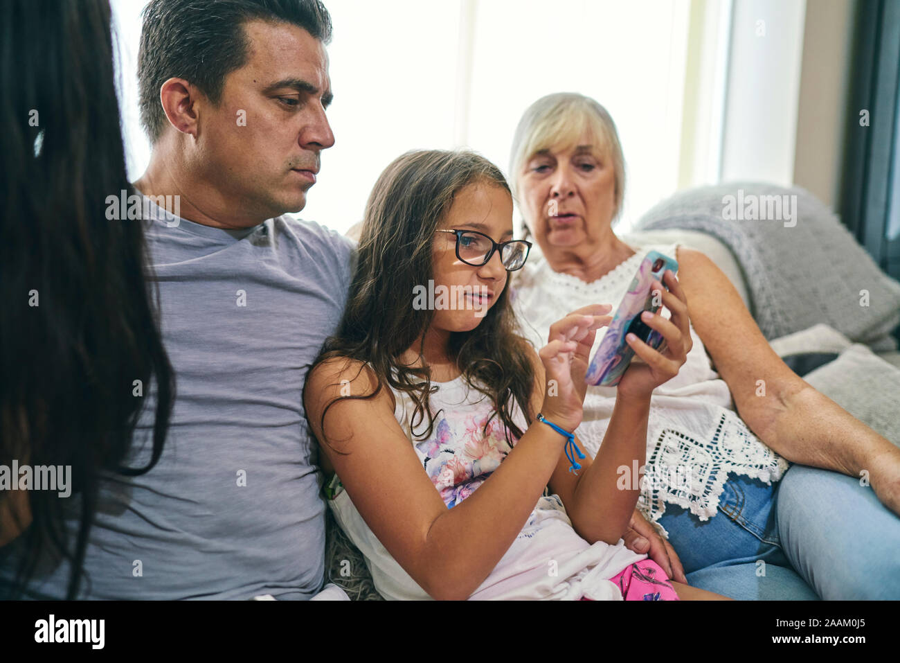 Three generation family enjoying computer games on sofa Stock Photo - Alamy