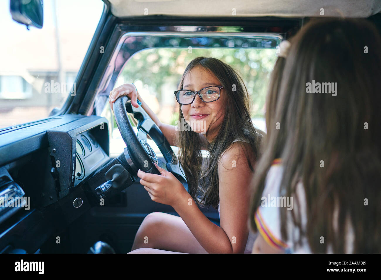 Young girls pretending to drive Stock Photo - Alamy