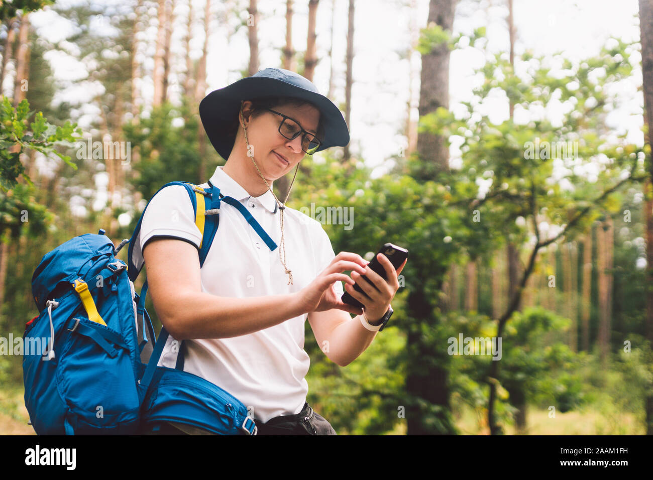 Girl tourist use smartphone on hike, looks maps and navigation. Woman ...