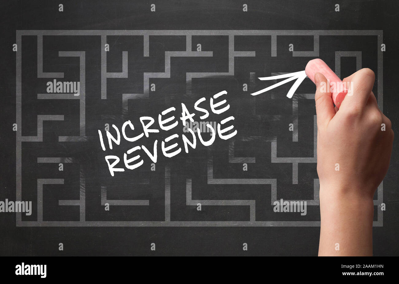 Hand drawing INCREASE REVENUE inscription with white chalk on ...